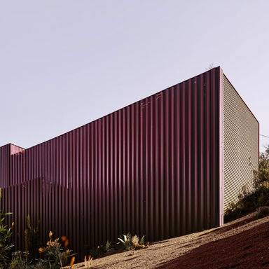 Enveloped in Maroon: An Architectural Masterpiece on a Hill