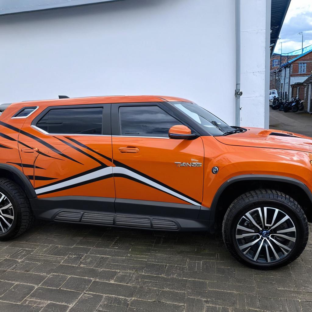 Stunning Orange Compact Car with Dynamic Black Stripes in Urban Setting