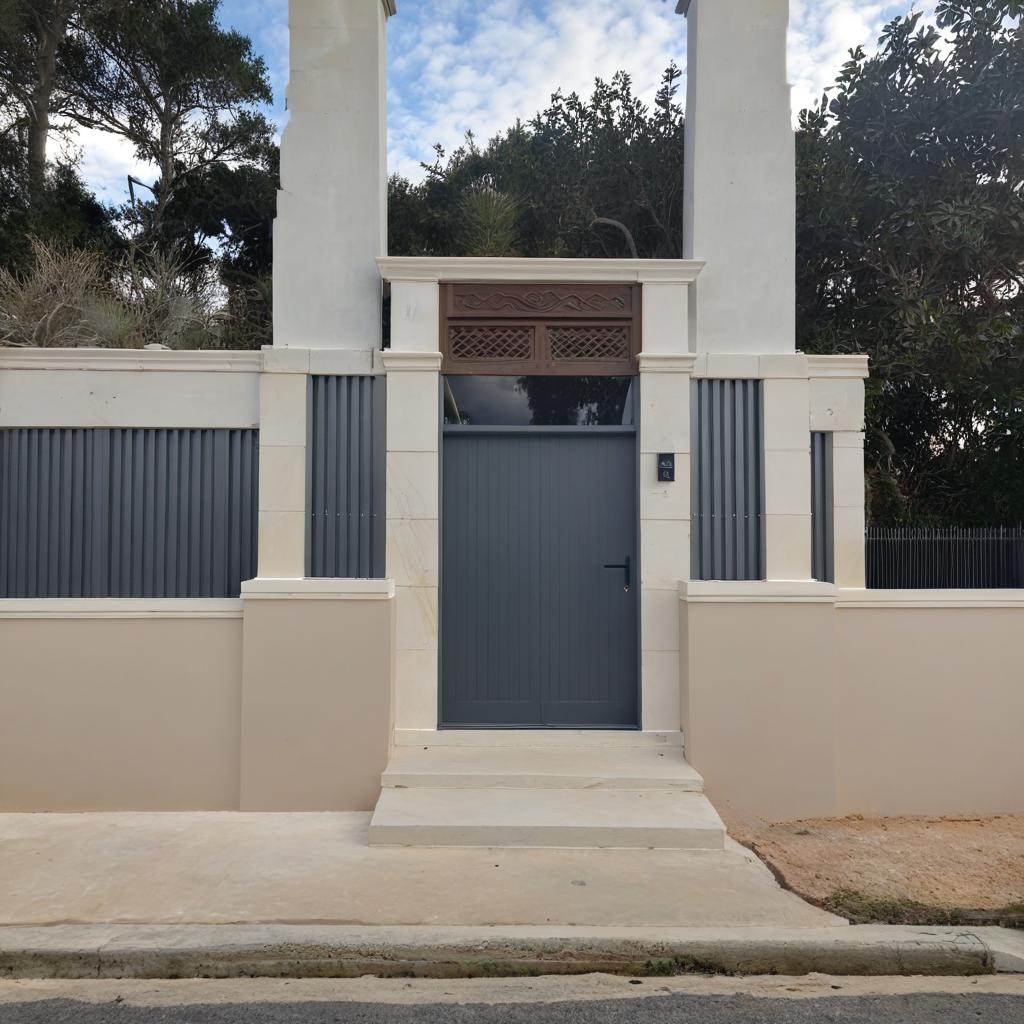 Stunning Modern Entrance Design with Grey Metal Door and Travertine Columns
